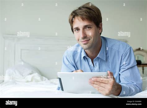 Man Lying In Bed Using Digital Tablet Stock Photo Alamy