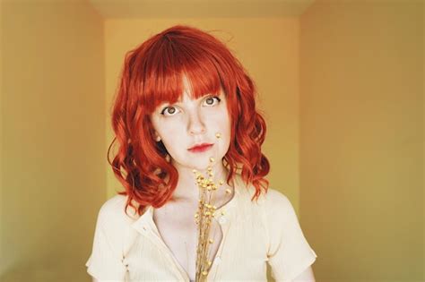 Premium Photo Redhead Woman With Flowers Against Yellow Wall