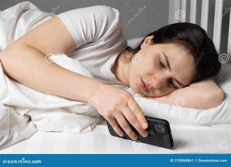 Una Mujer Se Acuesta En La Cama Y Lee Las Noticias O Mira Algo En Un Smartphone Antes De
