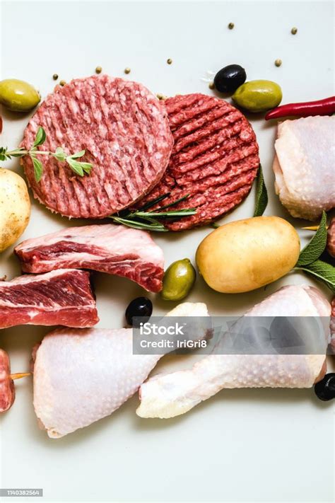 다양 한 종류의 생고기 닭고기 허벅지 돼지고기와 쇠고기 버거 갈비와 케밥 칠면조 미트볼 감자 고추 올리브 및 검은 올리브와 향기로운 허브로 조리 할 준비가 되어 있습니다