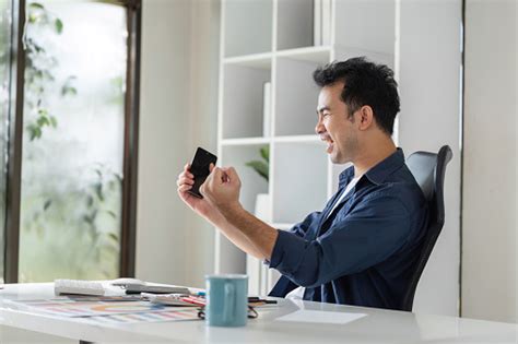 젊은 남성 그래픽 디자이너는 컴퓨터 및 디자인 도구를 사용하여 Modern Workspace에서 창의적인 프로젝트에 중점을