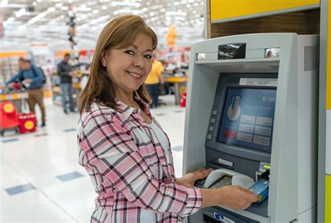 카메라 미소를 직면 하면서 Atm에서 돈을 인출 하는 슈퍼마켓에서 성숙한 여자 현금 자동 입출금기에 대한 스톡 사진 및 기타 이미지 현금 자동 입출금기 라틴 아메리카