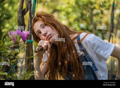 Beautiful Redhead Gardener Leaning Her Head On Hand And Over Thinking Stock Photo Alamy