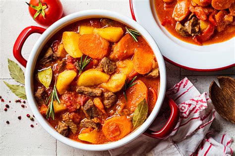 감자와 당근을 곁들인 소고기 스튜가 토마토 소스를 붉은 냄비에 넣고 회색 배경을 가지고 있습니다 Comfort Food에 대한 스톡 사진 및 기타 이미지 Istock