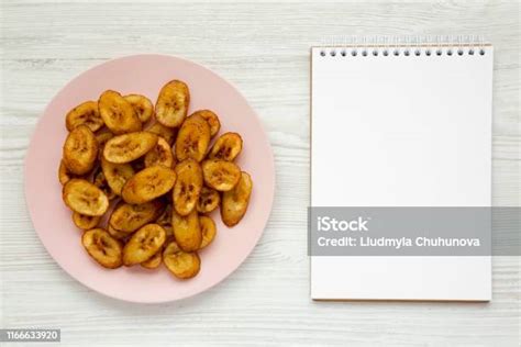 분홍색 접시에 수제 튀긴 질경이 흰색 나무 배경에 빈 메모장 머리 위 보기 평면 평신도 상단보기 위에서 공간을 복사합니다 건강한 식생활에 대한 스톡 사진 및 기타 이미지