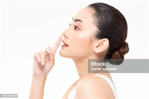 뷰티 아시아 여성들이 코 초상화를 건드리며 자연스러운 피부와 피부 관리로 건강한 모발과 피부를 가까이서 얼굴 뷰티 초상화를 클로즈업합니다 흰색 배경에 아름다움 개념 코에
