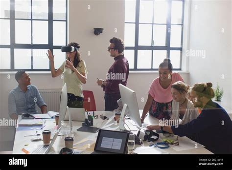 Computer Programmers Programming Virtual Reality Simulator Glasses In Open Plan Office Stock