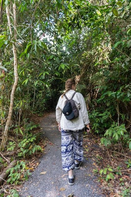 Premium Photo Blond Tourist Girl Walking In The Forest Jungle With