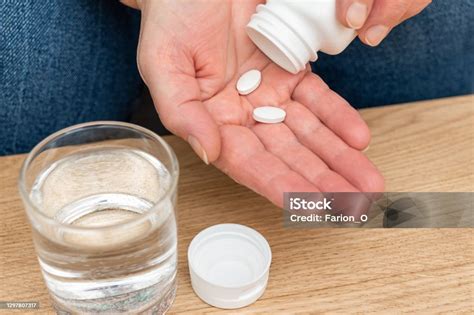 진통제 또는 항생제의 백색 알약 수석 여자 손 손바닥에 치료를 위한 물 의약품 및 비타민 보충제 개념유리 클로즈업 보기 Hydroxychloroquine에 대한 스톡 사진