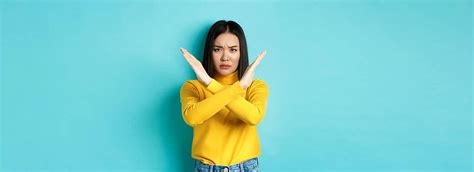 Assertive Korean Woman Stops And Disapproves Over Blue Background Photo
