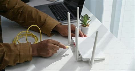 사람의 클로즈업보기는 인터넷 케이블을 라우터 소켓에 연결합니다 무선 인터넷 개념입니다 사진 Unsplash의 컴퓨터 이미지