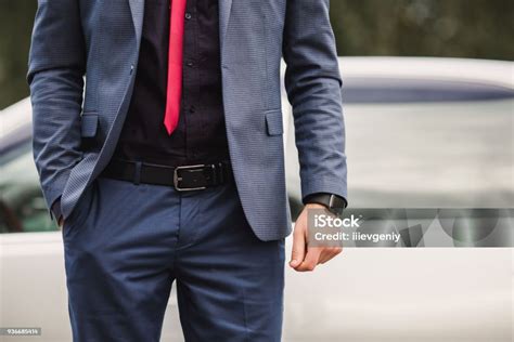 자동차의 배경에 빨간색 넥타이와 어두운 비즈니스 정장에 성공적인 사업 세련 된 남자입니다 유행 시계 손에 20 29세에 대한