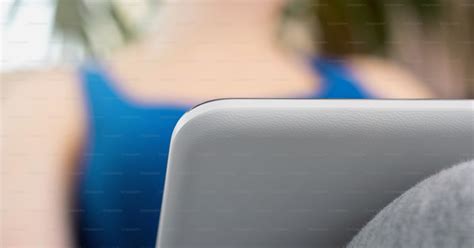 탱크 탑에 가슴이 큰 소녀 그녀의 무릎에 흰색 비즈니스 태블릿을 기대어 탱크 탑에 버스티 소녀 그녀의 무릎에 흰색 비즈니스 태블릿을 기대어 탱크 탑에 가슴이 큰 소녀 그녀의