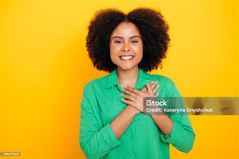 평화로운 개념입니다 마음에 손을 얹고 감사하는 몸짓을 하는 아름다운 성실한 브라질 또는 히스패닉계 곱슬곱슬한 젊은 여성은 고립된