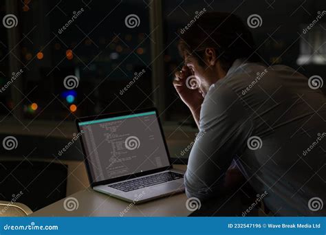 Caucasian Male Programmer Sitting At Desk Using Laptop With Coding On