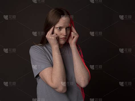 年轻女子头痛欲裂，双手托着太阳穴，疼痛难忍