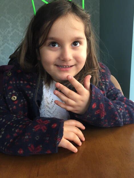 Premium Photo Cute Girl Sitting At Table