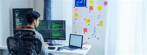 Asian Software Developers Working On Multiple Screens Displaying Code