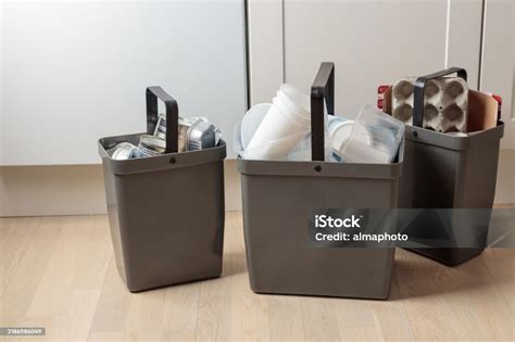 폐기물을 재활용하고 플라스틱 종이 및 금속 품목을 별도의 용기에 적절하게 폐기하기 위해 분류합니다 부엌 바닥에 있는 쓰레기통에 담긴 재활용 가능한 재료 0명에 대한 스톡