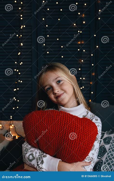 Девушка обнимая красную подушку на зимний день Стоковое Изображение изображение насчитывающей