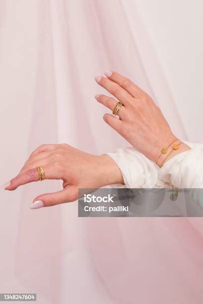 Beautuful Woman Hands With Ring And Bracelets Set Against A Pink