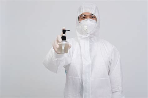 바이러스 박테리아를 살균하기위한 생물학적 보호 유니폼 정장 의류 마스크 손 소독제 디스펜서 장갑을 착용하는 남자 과학자 건강