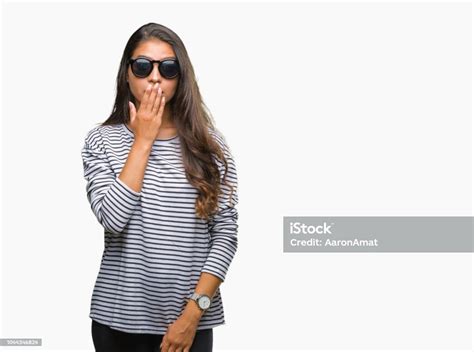 젊은 아름 다운 아랍 여자 입 실수에 대 한 손으로 다루는 충격된 절연된 배경 위에 선글라스를 착용 비밀 개념입니다 가리기에 대한 스톡 사진 및 기타 이미지 Istock
