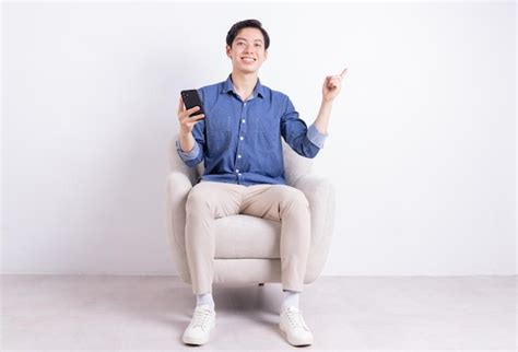 Joven Asi Tico Sentado En Un Sill N Sobre Fondo Blanco Foto Premium