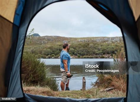 텐트 전망 야외 및 캠핑에서 자연 속에서 모험 휴가 또는 휴가를 즐길 수 있는 호수 옆의 남자 탐험가 쌍안경 및 아침 강 댐 또는 물로 자연 휴식 휴식 또는 휴양지 관광