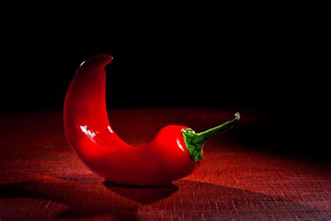 고추가 닫힙 칠레 고추 나무 보드에 붉은 배경에 야채 극적인 빛을 예술적 효과로 대조합니다 후추 근처의 텍스트를 위한 공간과