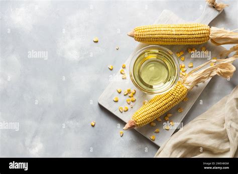 Corn Oil In Glass Bowl With Dried Corn Groats And Kernels On Rustic