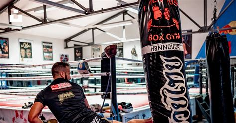 흑백 셔츠와 검은 색 반바지를 입은 여자는 검은 색과 빨간색 권투 장갑에 서 있습니다 사진 Unsplash의 무료 스포츠 이미지