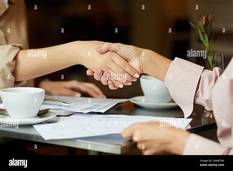 Close Up Of Two Businesswomen Shaking Hands To Each Other While Sitting