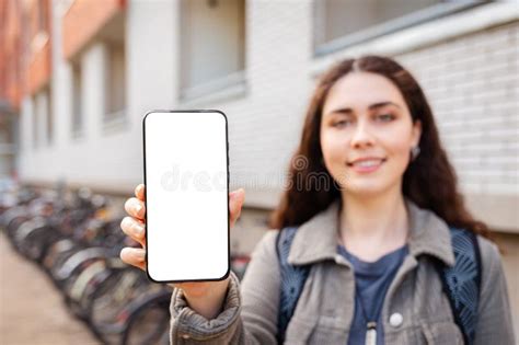 Blurred Portrait Of Young Caucasian Woman Shows Smartphone With White Mock Up Screen Rent Bike