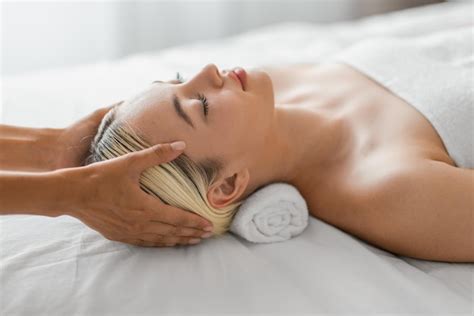 Premium Photo A Woman Is Lying Down On A Massage Table At A Spa While A Professional Masseuse