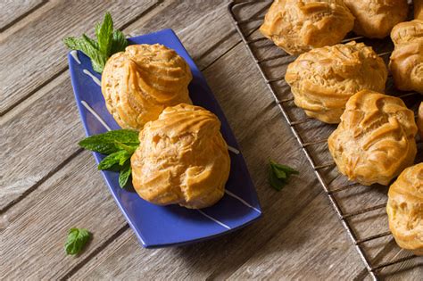 숙성 된 나무 배경에 민트 잎과 손으로 그린 파란색 타원형 접시에 크림 맛있는 큰 크림 퍼프 선택적 초점 0명에 대한 스톡 사진 및 기타 이미지 Istock