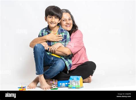 Portrait de la bonne grand mère indienne et de son petit fils hug assis sur le sol isolé sur
