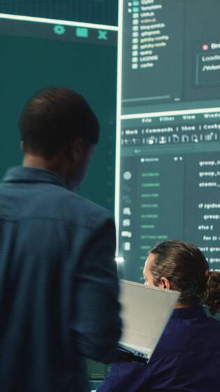 Vertical Governmental Hackers Analyzing Cyber Threats On Big Screens