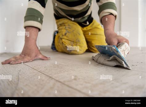 Grouting Ceramic Tiles Tilers Filling The Space Between Ceramic Wood Effect Tiles Using A