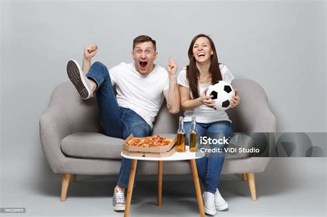 흰색 티셔츠에 커플 여자 남자 축구 팬을 웃 고 기 뻐 요 회색 배경에 고립 된 축구 공을 좋아하는 팀 응원 지원 사람들의 감정 스포츠 가족 레저 라이프 스타일 개념입니다