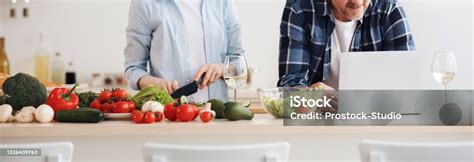 부엌에서 건강한 식사를 즐기고 준비하는 커플과 노트북에서 조리법을 읽는 커플 요리하기 음식 준비에 대한 스톡 사진 및 기타 이미지 요리하기 음식 준비 중년 커플 요리