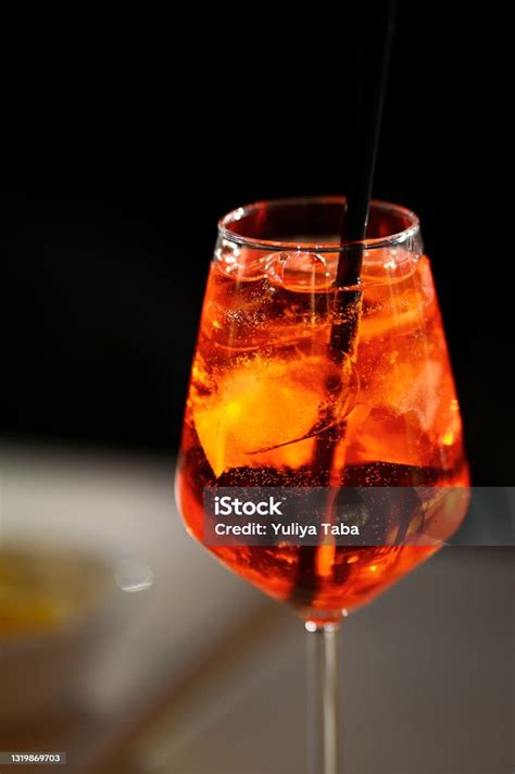 아이스 큐브가 있는 와인 잔에 이탈리아 칵테일 아페롤스 프리츠 흐리게 된 배경을 가진 선택적 초점 공간 텍스트를 복사합니다 여름 방학 컨셉 스프리츠에 대한 스톡 사진 및