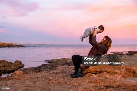 해변에서 가족의 라이프 스타일 아기가 재미와 일몰에 바다에 앉아 그의 어머니와 함께 그를 해제 2명에 대한 스톡 사진 및 기타 이미지 Istock