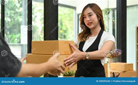 Smiling Young Woman Receiving Parcel Package Of Goods From Deliveryman Home Delivery Shopping