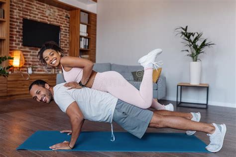 Smiling Millennial African American Lady In Sportswear Lies On Husband
