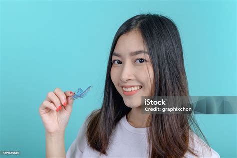 파란 화면 배경에 치열 교정 보유자를 들고 미소 아시아 여성 치과 치료와 건강한 치아 20 24세에 대한 스톡 사진 및 기타