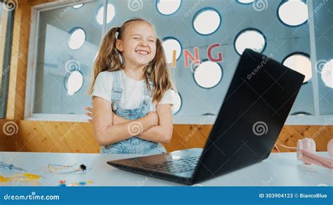 smart cute girl using laptop while looking and laughing at camera