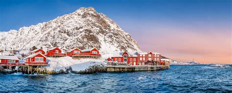 전통적인 붉은 목조 어부들은 겨울에 로포텐 섬에서 로르부라고 불리는 물 속의 죽마 위에 오두막을 짓습니다 해질녘 노르웨이 북부 모스케네소야 섬의 모스케네스 시정촌에 있는 A