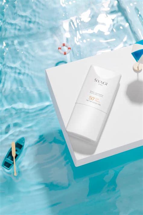 Spf50 광고 깨끗한 당구 물 상업 수직 쐈어 스킨케어 얼굴 크림 자외선 차단제 컨테이너 태양 보호 화장품에 관한 무료 스톡 사진