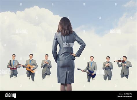 Man Orchestra Playing Different Music Instruments And Woman Leader Stock Photo Alamy